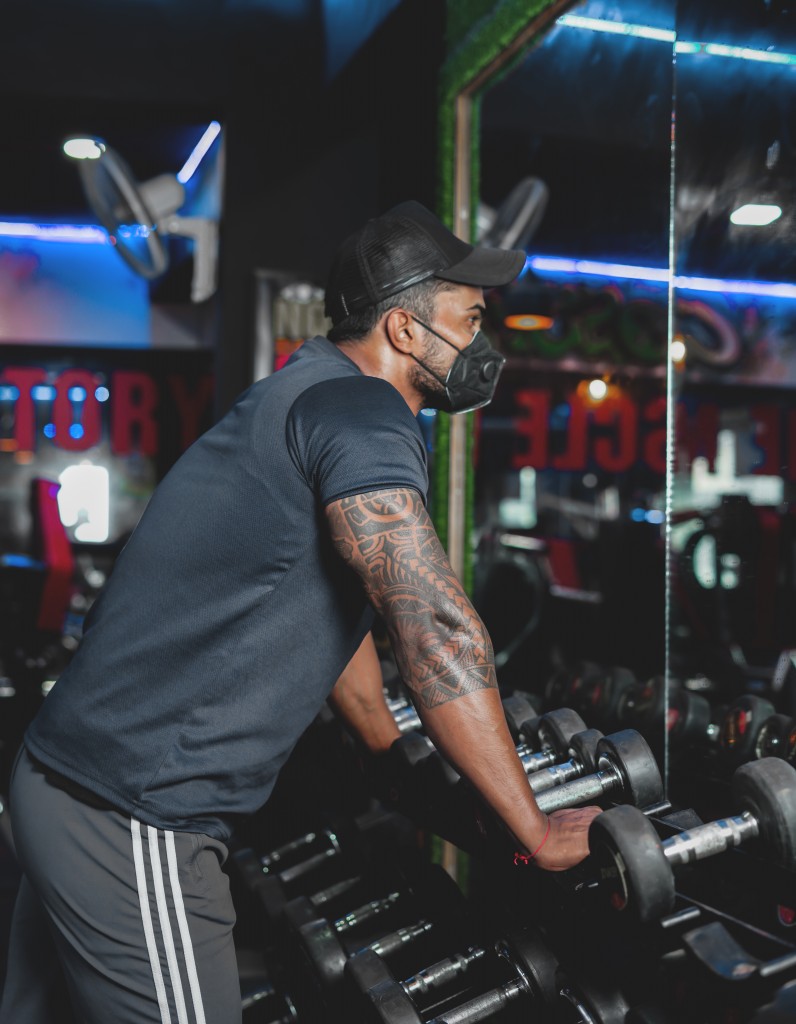 A bodybuilder with mask standing in front of a mirror - PixaHive