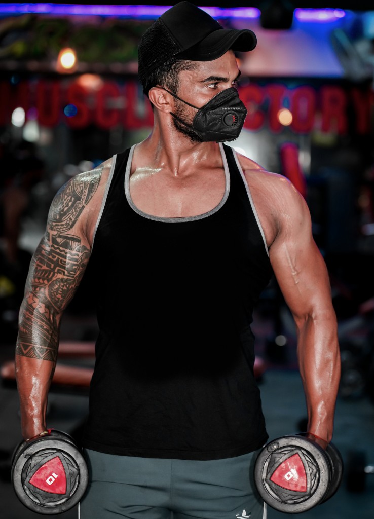 Bodybuilder wearing mask in gym - PixaHive