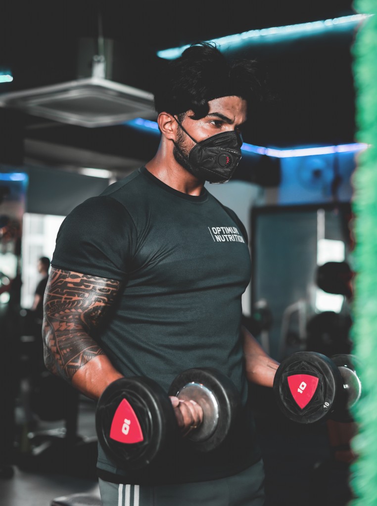 Man working out in a gym with a mask on - PixaHive