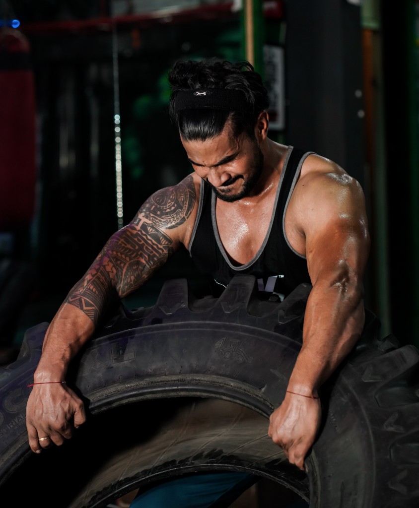 Strong man lifting Tractor tyre with arms - PixaHive