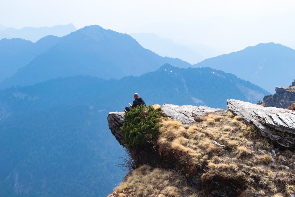 A person sitting on mountain edge - PixaHive
