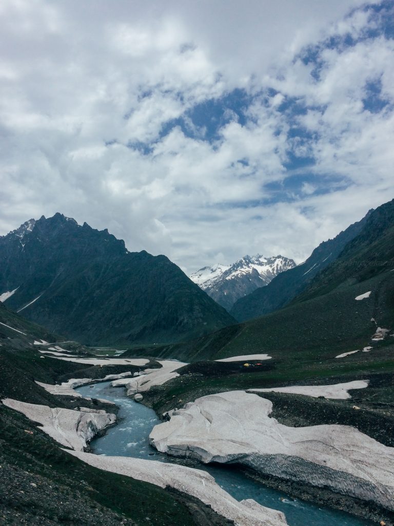 Blue river flowing through the valley surrounded with high mountains ...