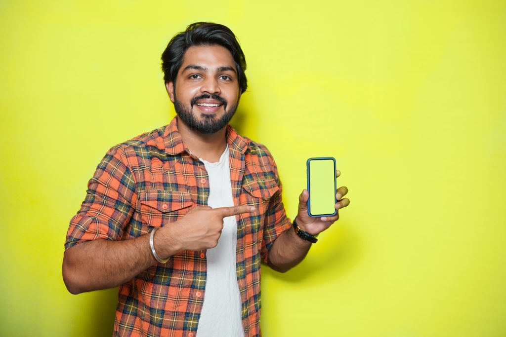 Indian male model pointing at cell phone - PixaHive