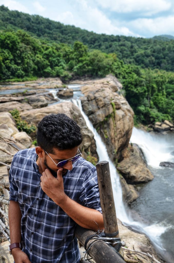 Man standing at the top of waterfall - PixaHive