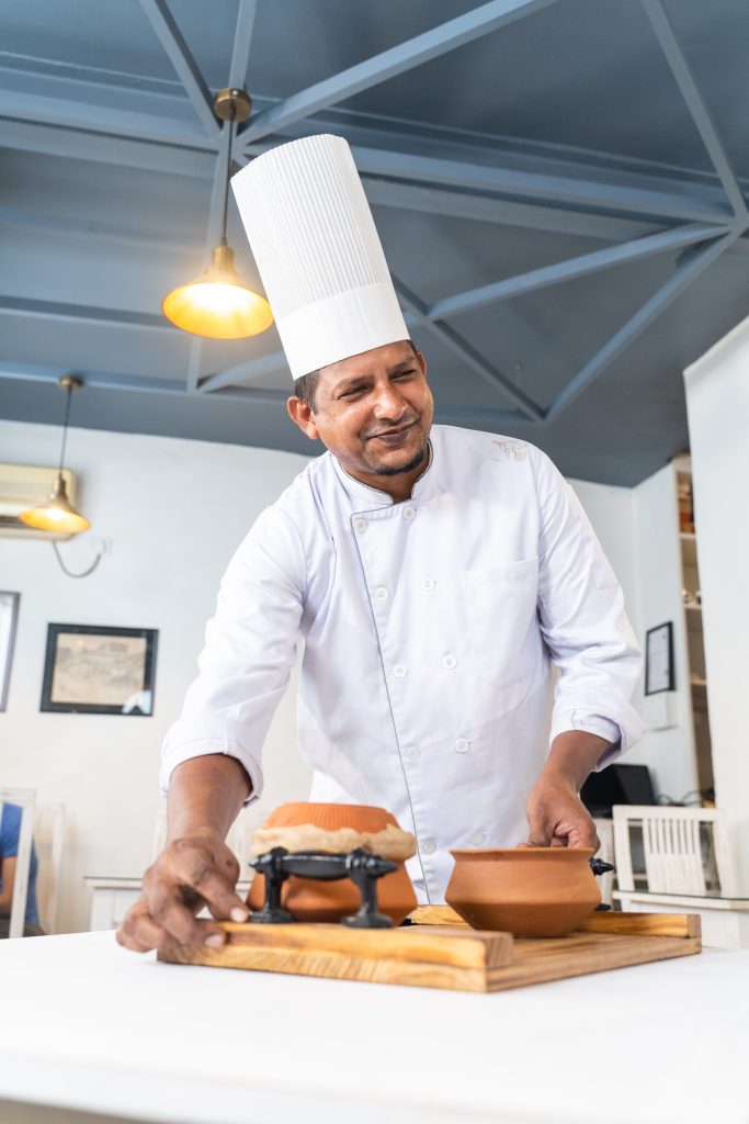 Chef smiling while offering food - PixaHive