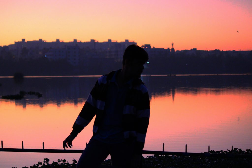 Guy standing in front of the lake - PixaHive