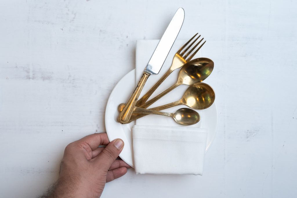 Hand holding cutlery set - PixaHive