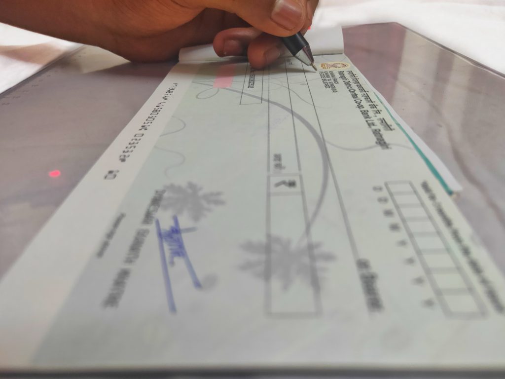 Person filling up cheque details - PixaHive