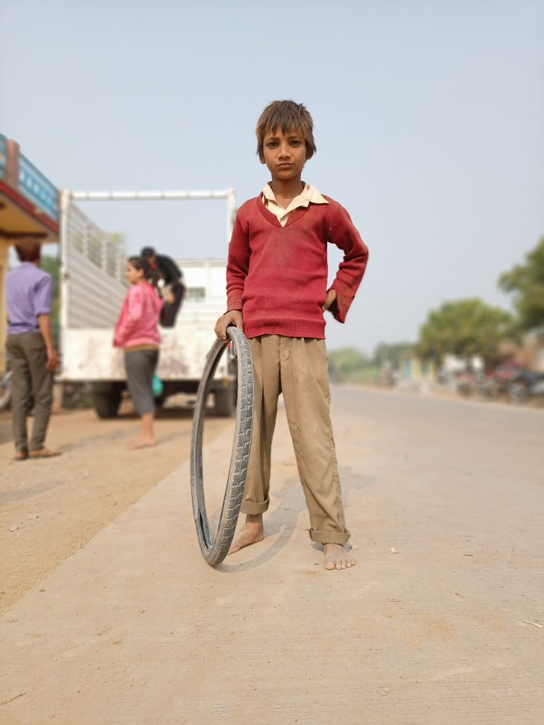 A village boy playing with bicycle tire - PixaHive