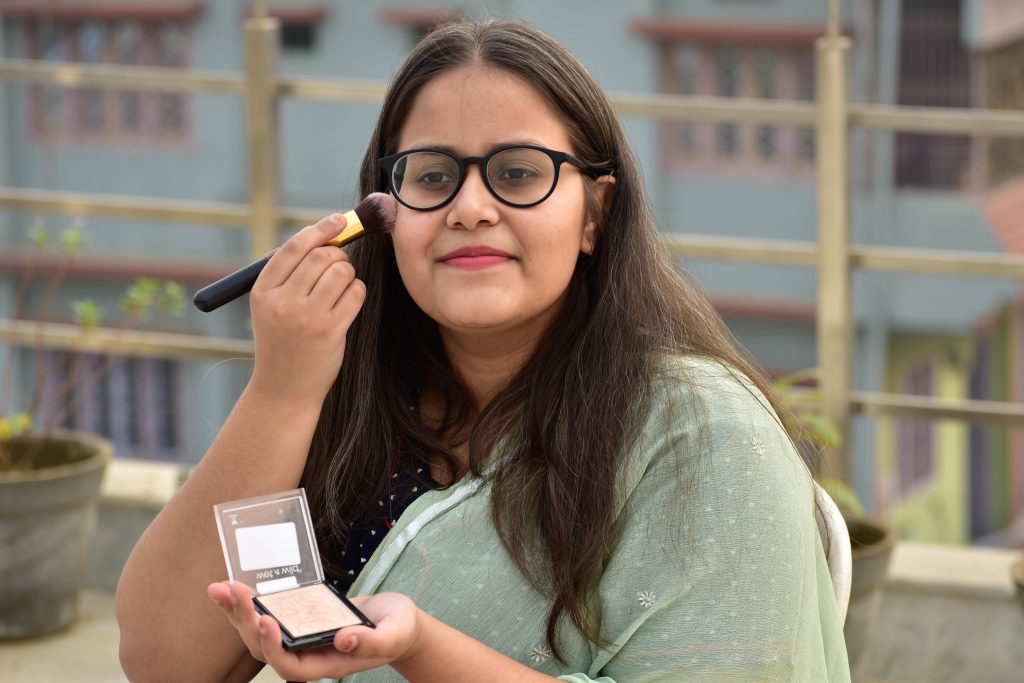 Girl applying highlighter on face - PixaHive