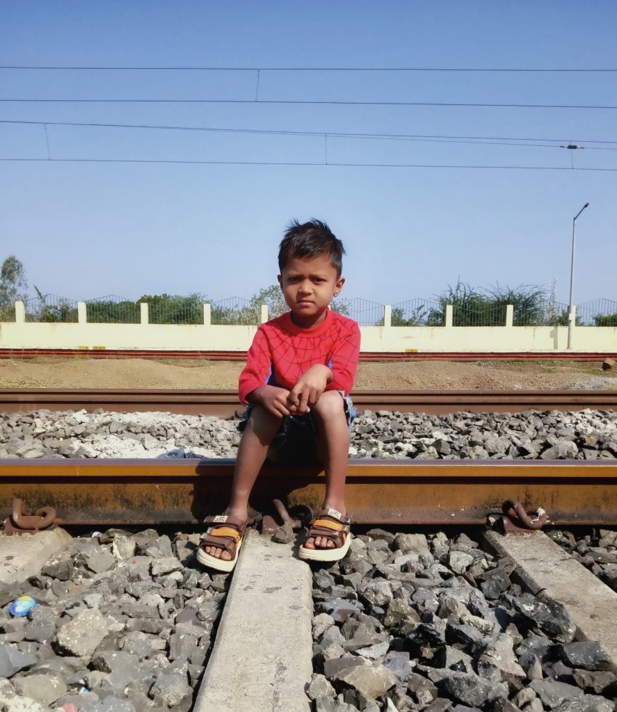 A kid sitting on railway track - PixaHive