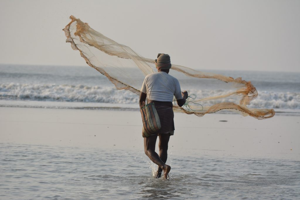A fisherman spreading his net in water - PixaHive