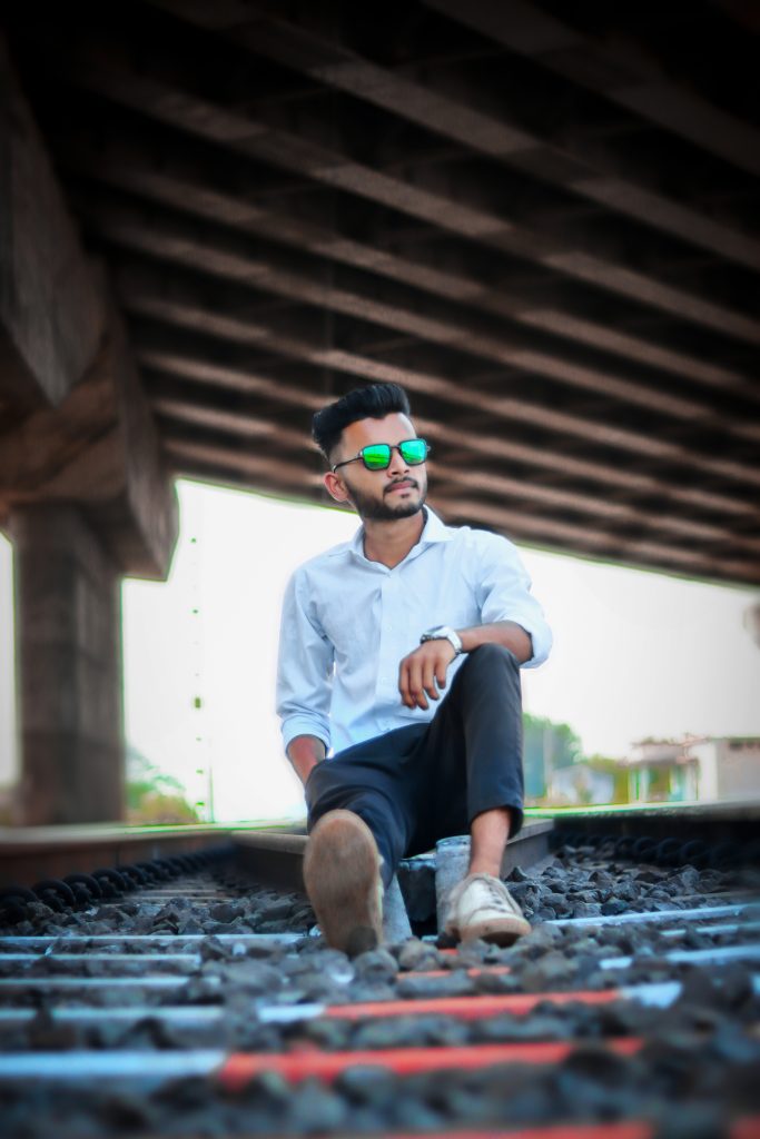 A male model sitting on railway track - PixaHive