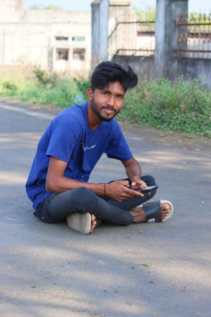 A street boy sitting on a road - PixaHive